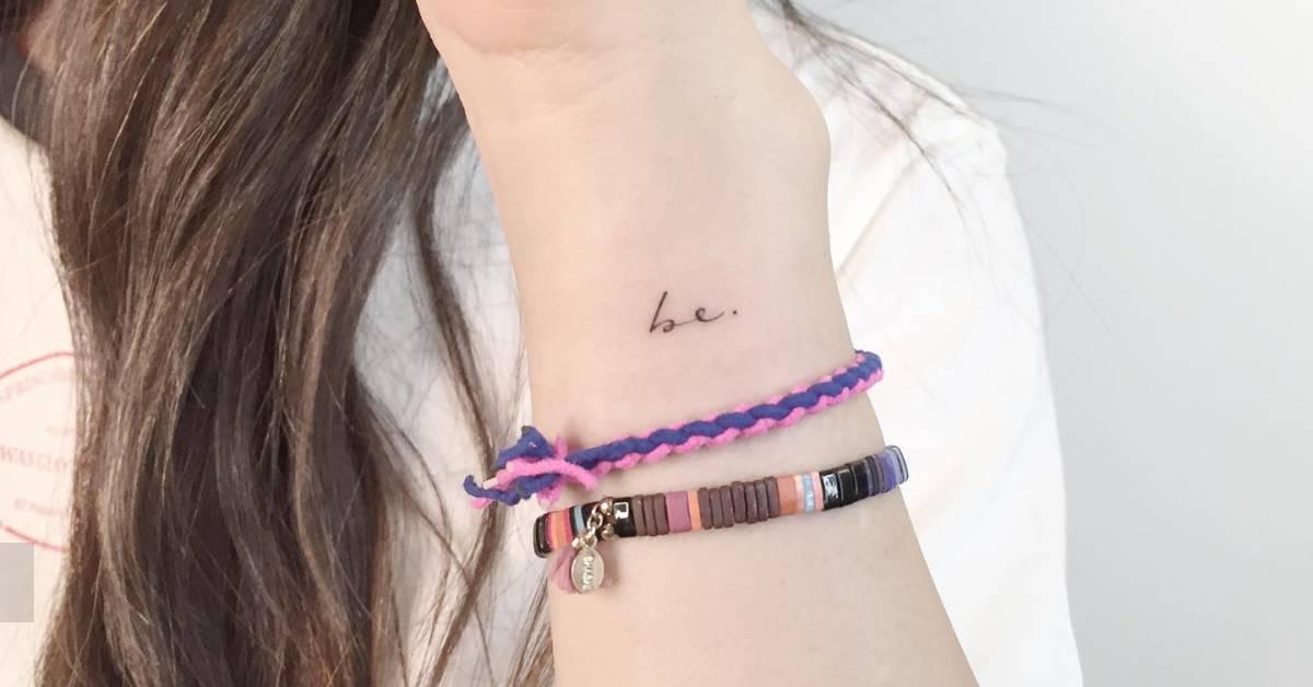 Lettering tattoo of the word "be" located on the wrist.
