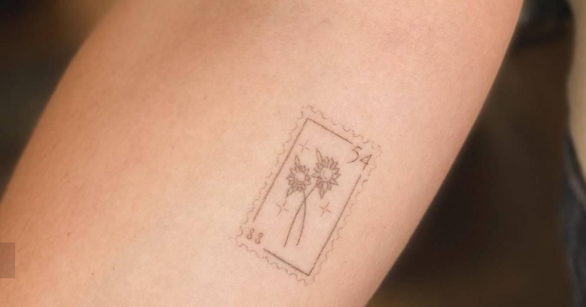 Healed fine line flower stamp tattoo located on the