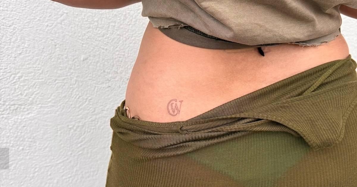Initials tattoo located on the hip, minimalistic style.
