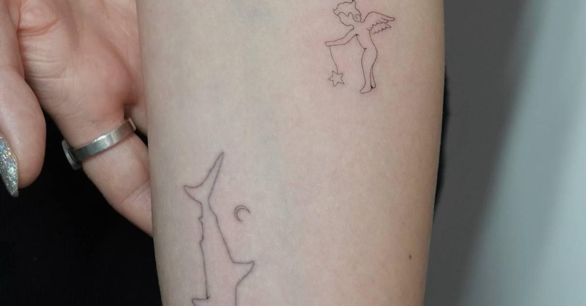 Fine line style shark and cherub tattoos placed on the