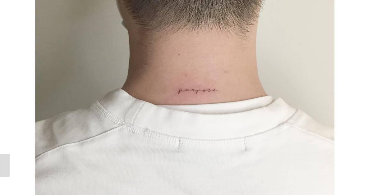 Lettering tattoo that says "purpose" done on the back