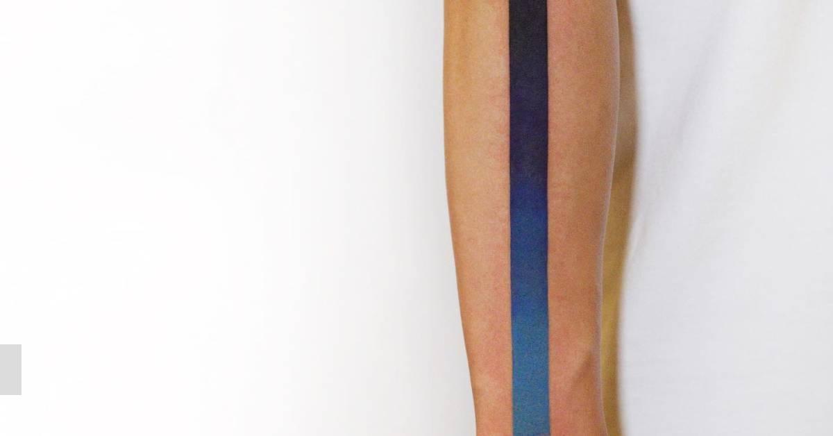Large blue spectrum tattoo located on the forearm.