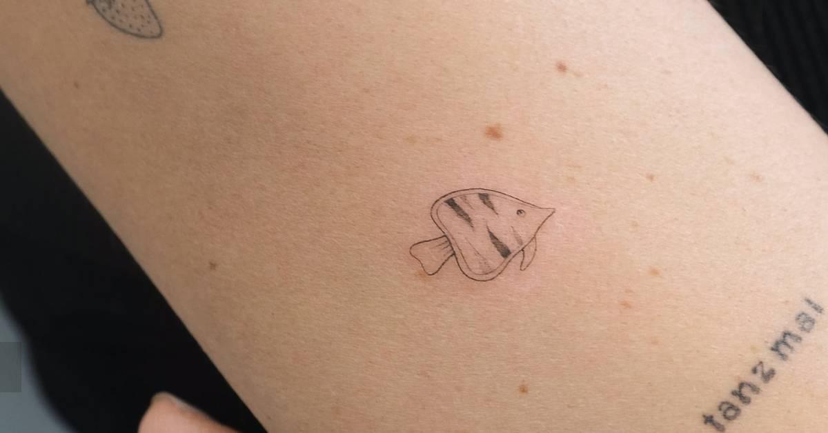 Single needle butterflyfish tattoo located on the upper