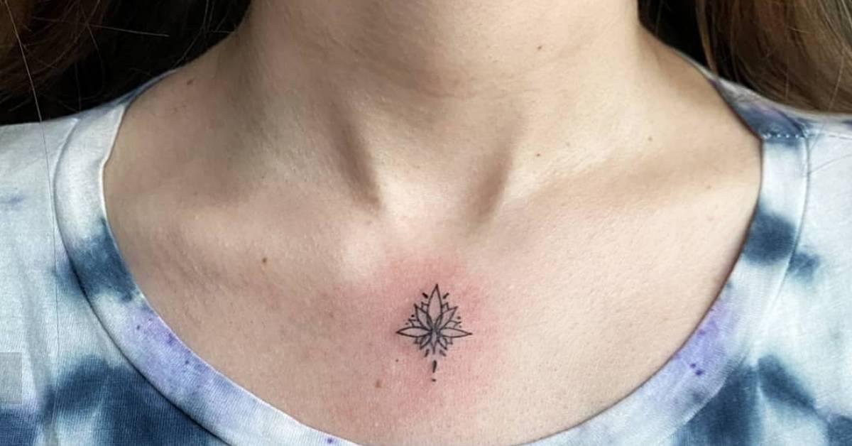 Minimalist lotus flower tattoo on the chest.