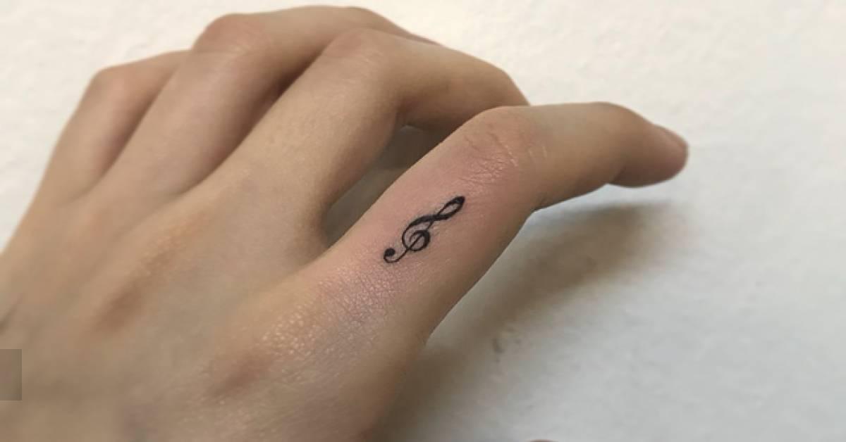 Minimalistic treble clef tattoo located on the finger.