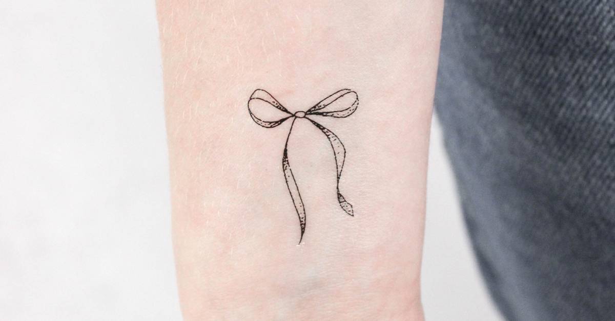 Small fine line ribbon bow temporary tattoo done on the