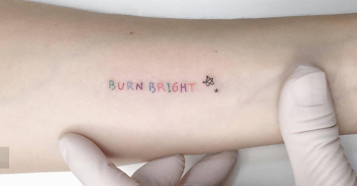 "Burn bright" colorful lettering tattoo placed on the