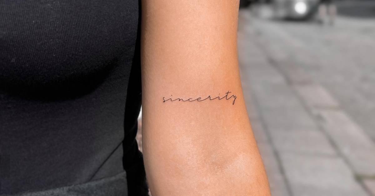 Tattoo of the word "sincerity" located on the bicep.