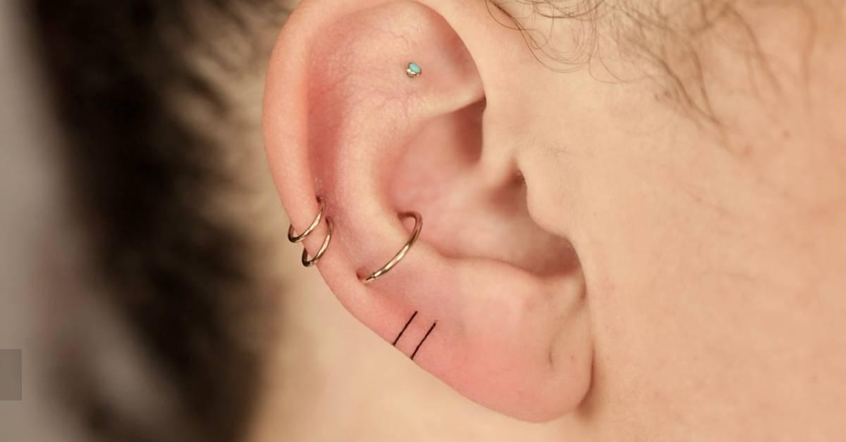 Minimalistic style lines tattooed on the ear.
