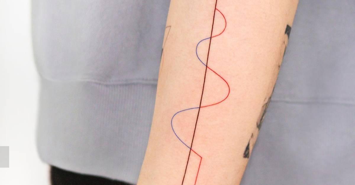 Abstract spectrum lines tattooed on the forearm.