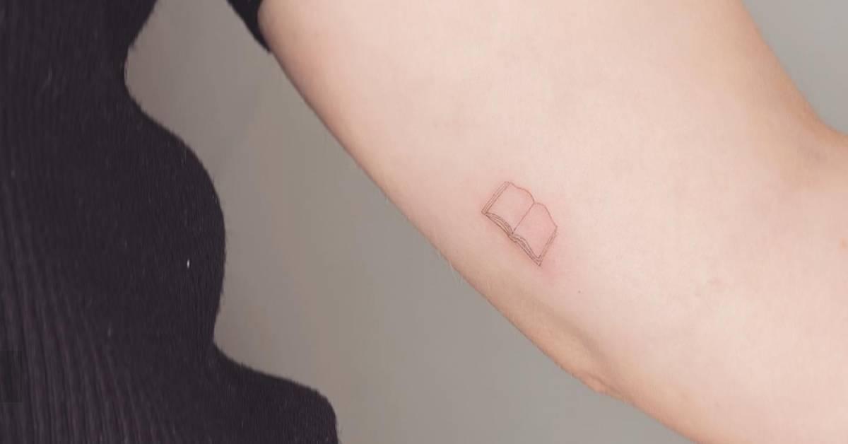 Fine line book tattoo located on the inner arm,