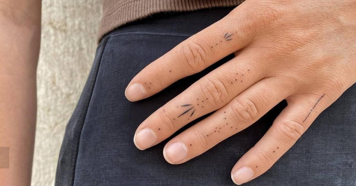 Hand poked ornamental finger composition tattoo.