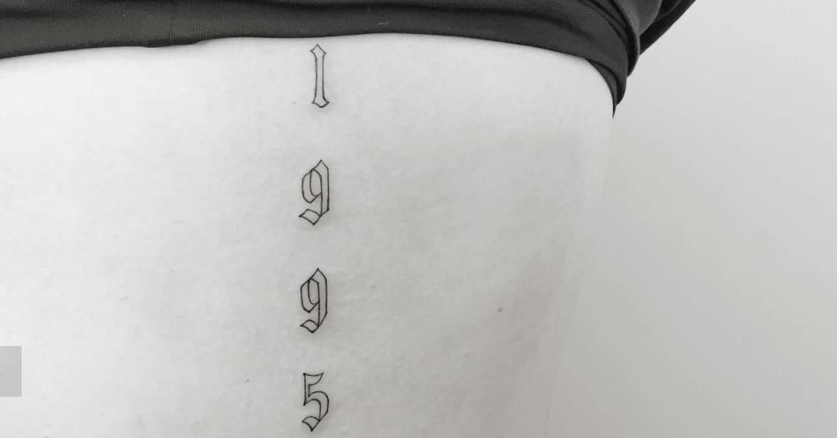 "1995" birth year in gothic font tattooed on the rib.