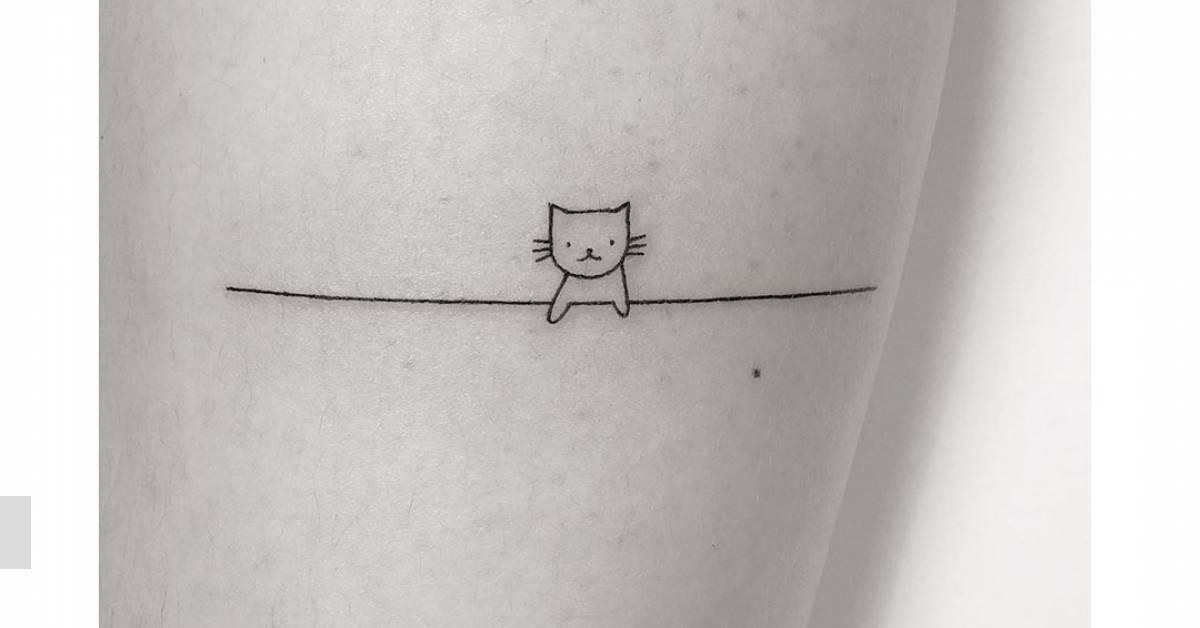 Minimalistic style cat tattoo located on the inner arm.