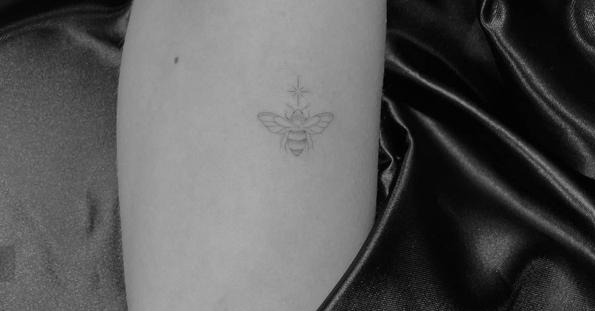 Fine line style bee tattoo placed on the forearm.