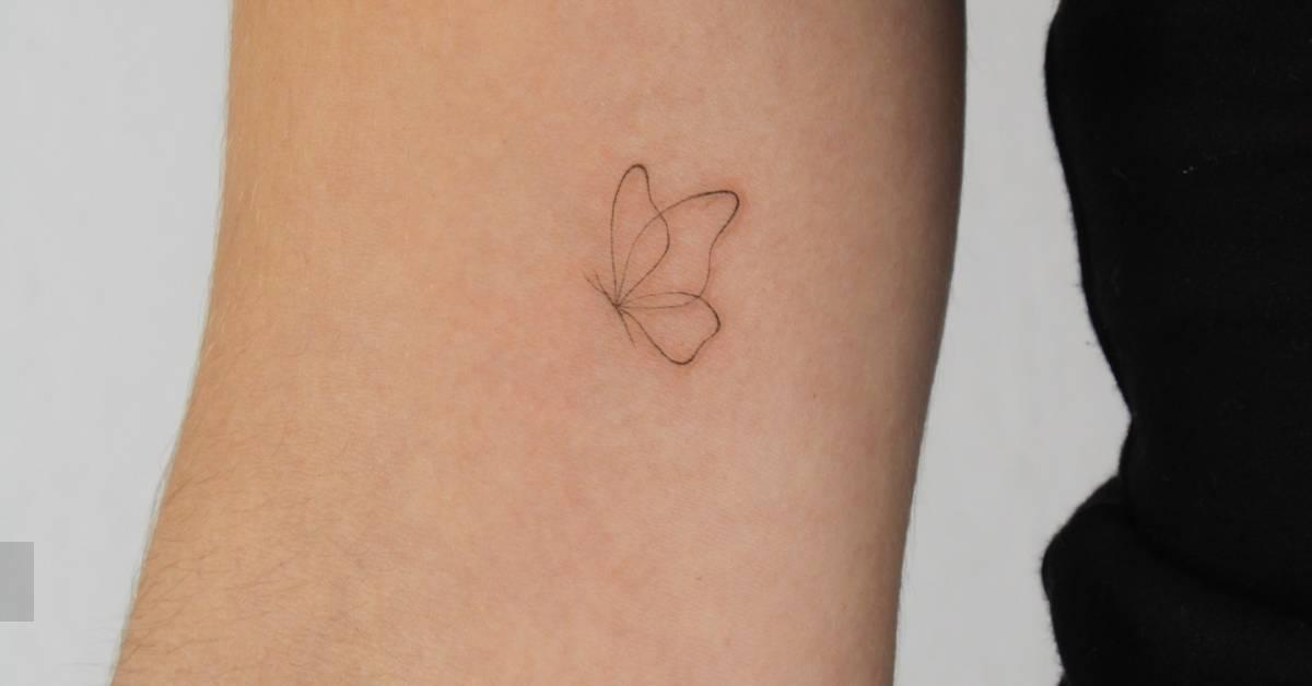 Fine line style butterfly tattoo located on the inner