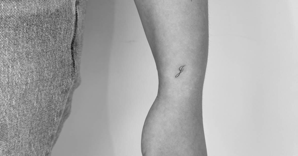 Tiny letter "J" tattoo located on the wrist.