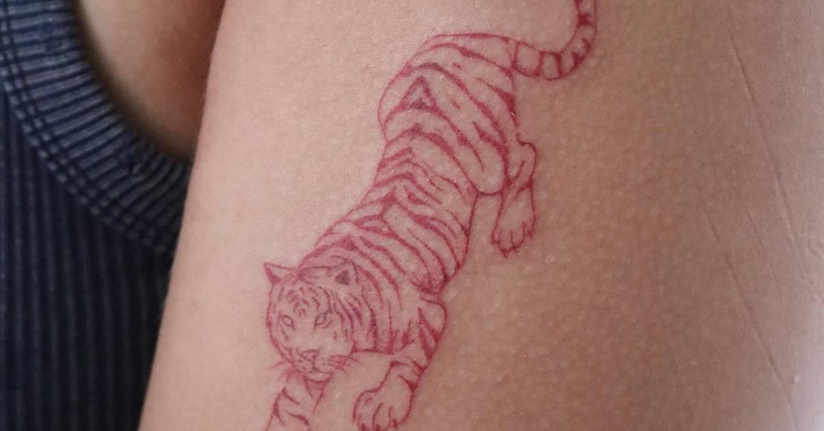 Red tiger tattoo in fine line style located on the