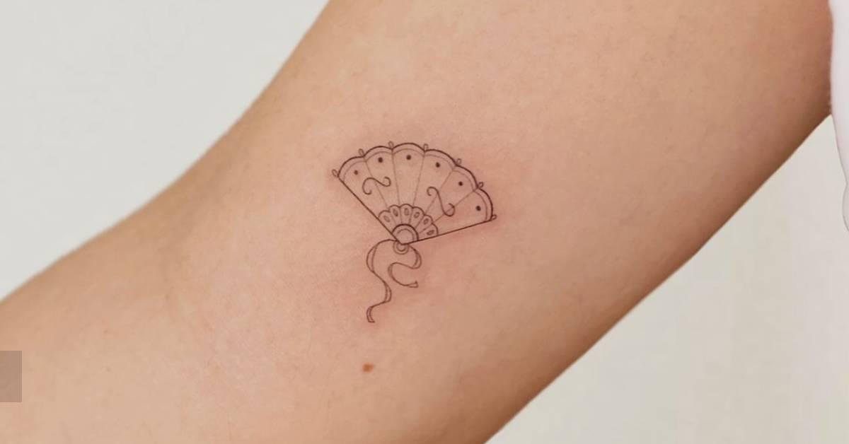 Hand fan tattoo in fine line style located on the inner