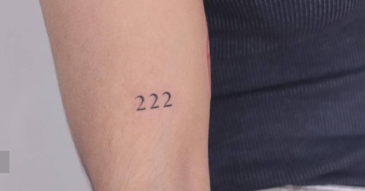 Angel number "222" tattoo located on the upper arm.