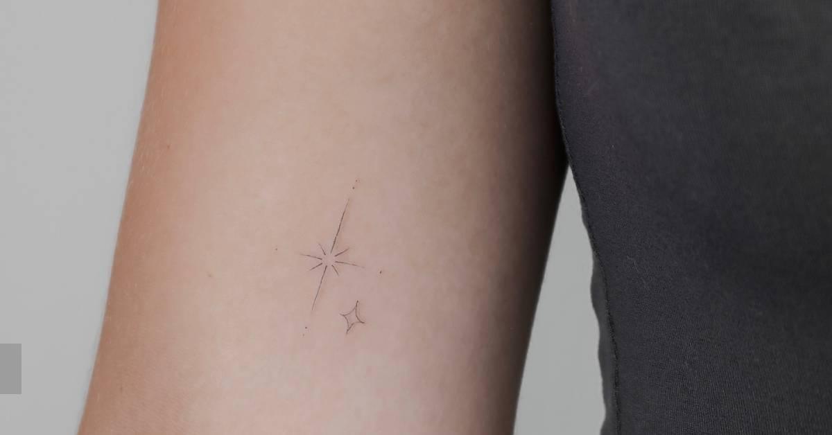 Minimalistic fine line stars tattooed on the inner arm,