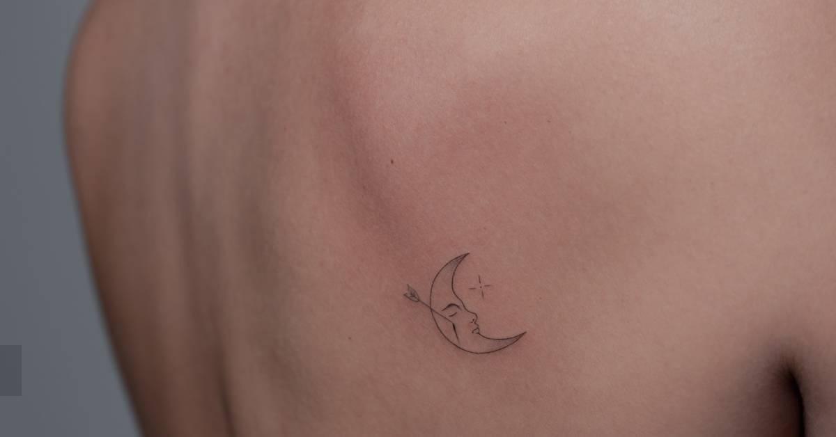 Single need crescent moon face tattoo located on the