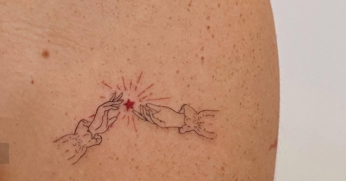Hands and star tattoo in fine line style located on the