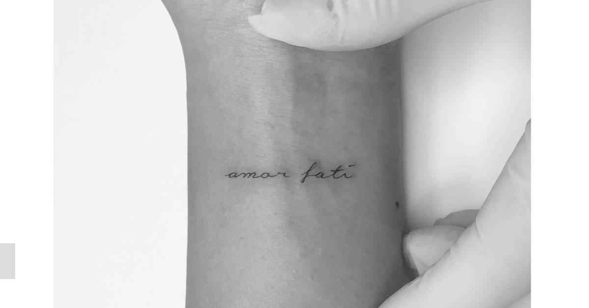 Handwritten lettering tattoo that says "amor fati"