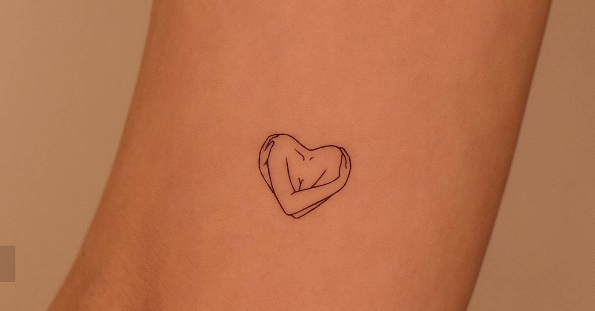 Fine line self hug tattoo located on the inner arm,