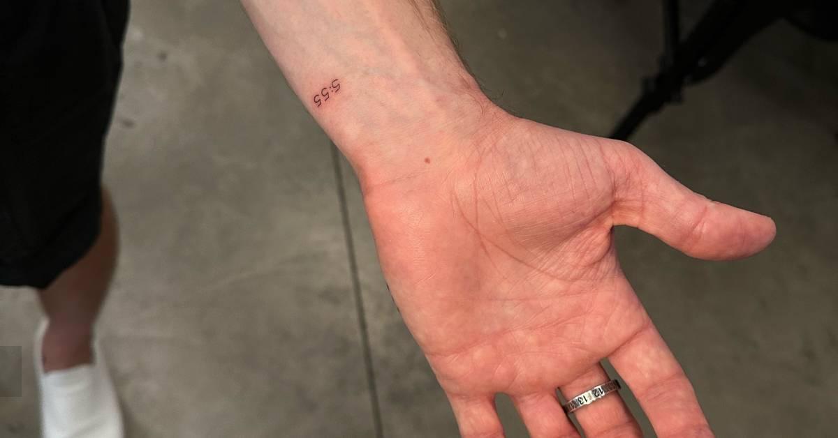 Hour "5:55" tattoo located on the wrist.