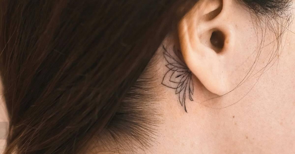 Hand poked lotus flower tattoo placed behind the ear.
