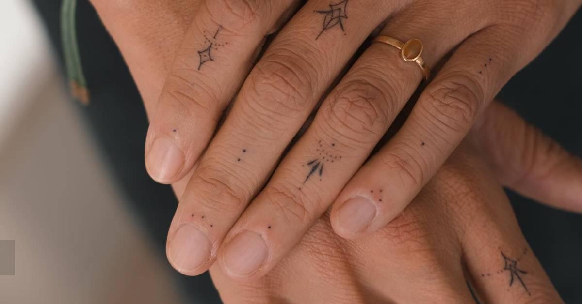 Hand poked finger composition tattoos.