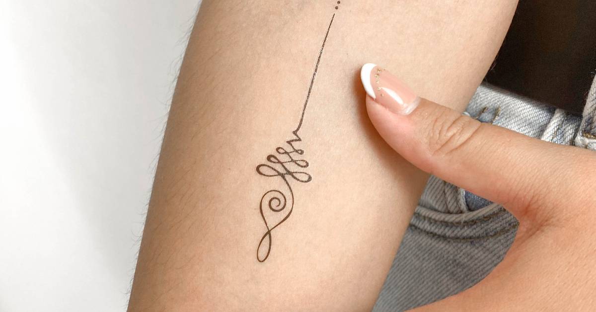 Fine line style unalome temporary tattoo located on the