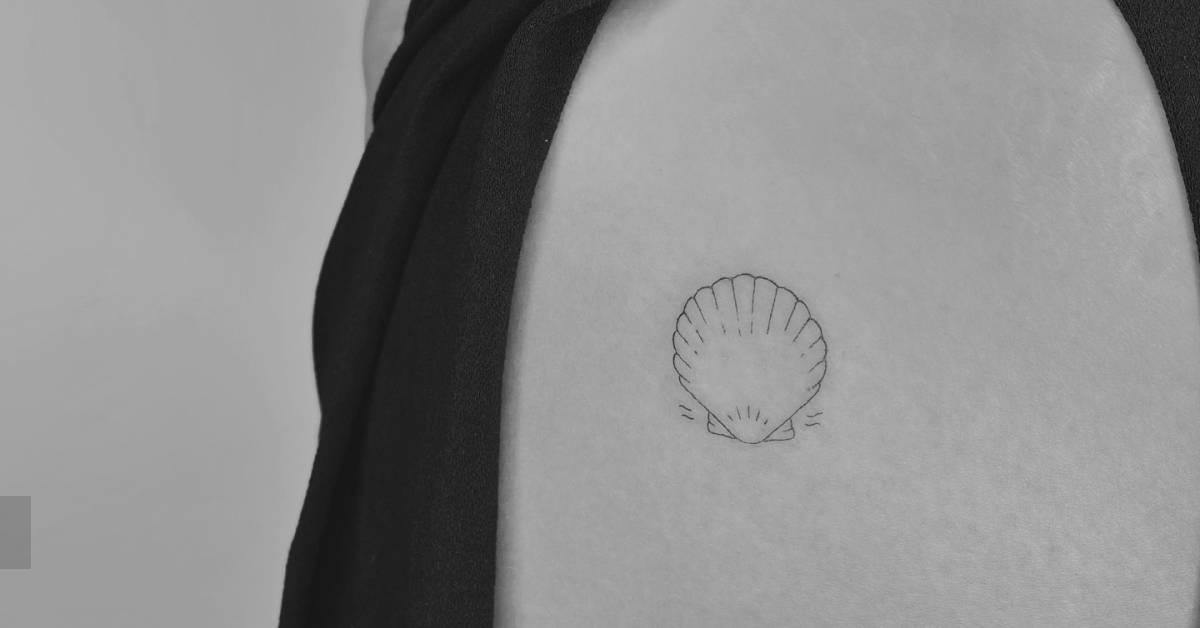 Fine line style scallop shell tattoo done on the upper