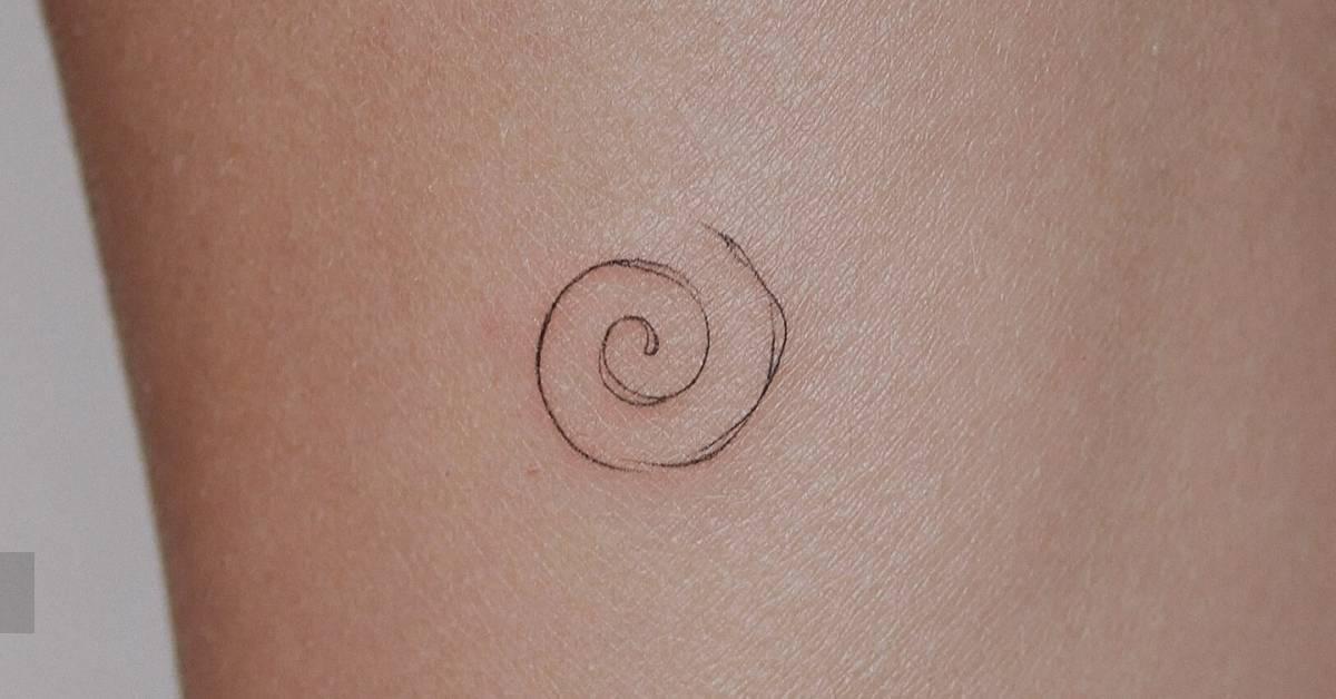 Fine line style little spiral tattoo placed on the