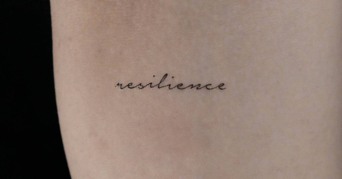 "Resilience" temporary lettering tattoo located on the