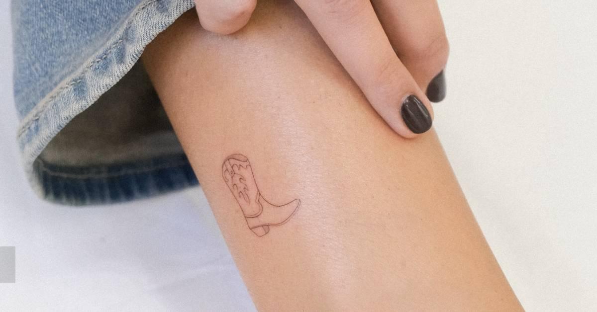 Fine line style cowboy boot tattoo located on the