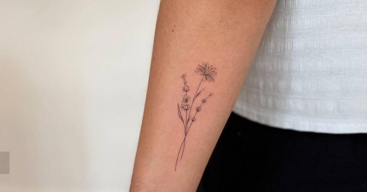 Delicate flower bouquet tattoo located on the forearm.