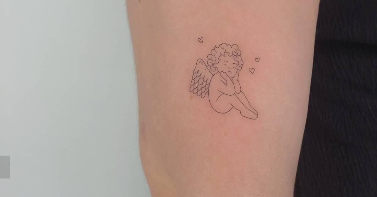 Fine line style cherub tattoo located on the upper arm.