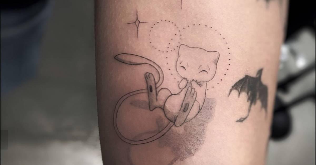 Cartoon style Mew tattoo located on the inner forearm.