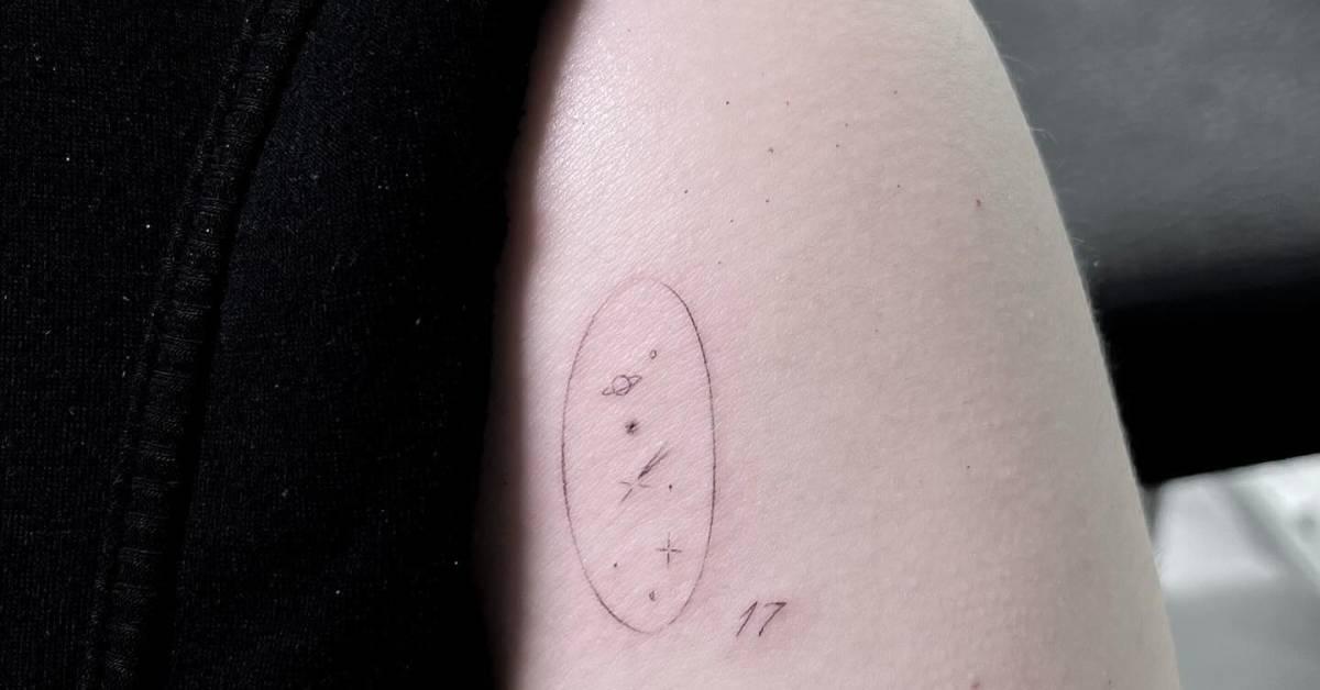 Minimalistic style universe and number "17" tattoo