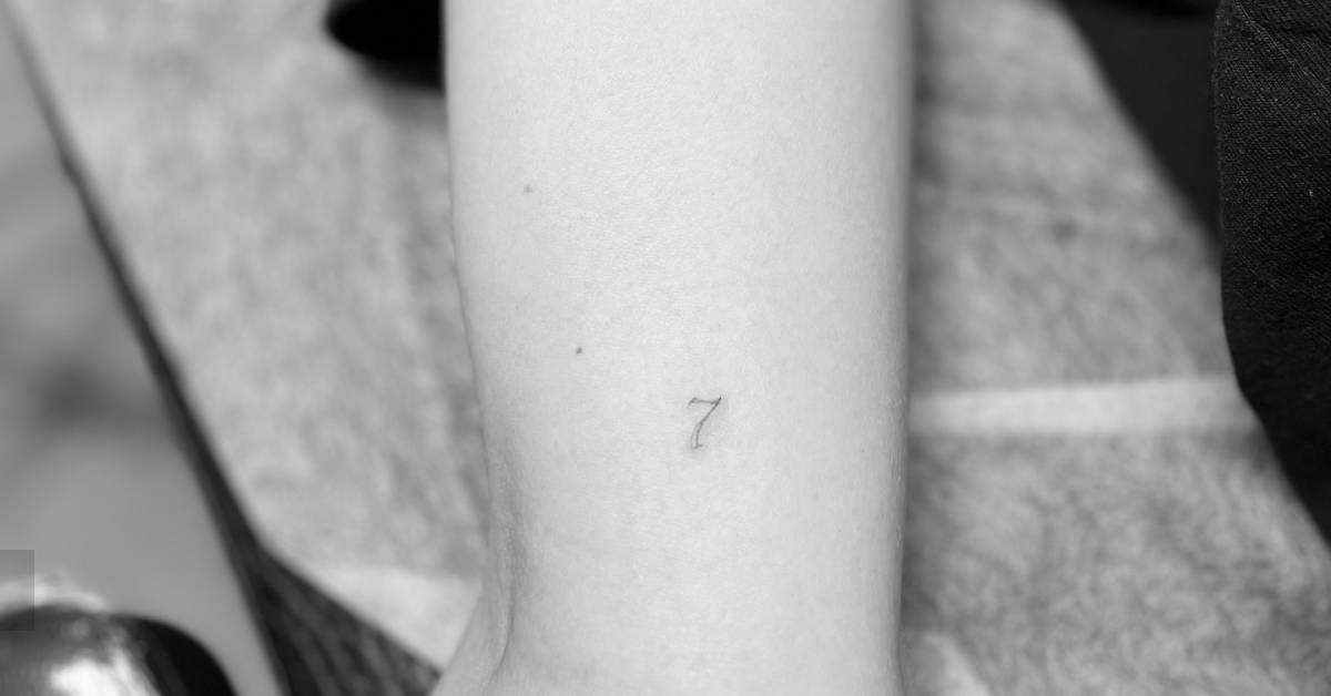 Mini tattoo of the number "7" located on the inner arm.
