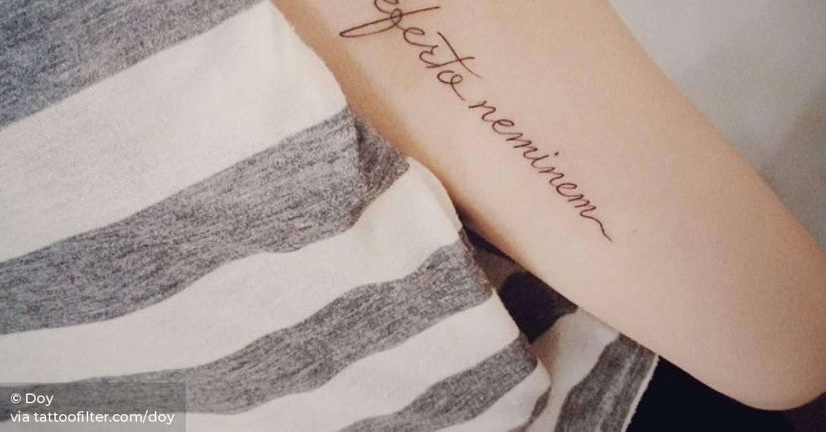 "Deferto neminem" tattoo on the right tricep.