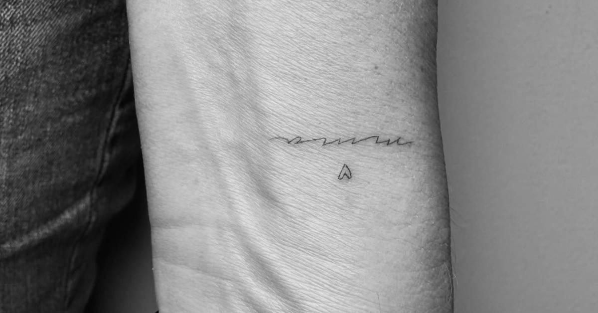 Handwritten name "Mina" and heart tattoo located on the