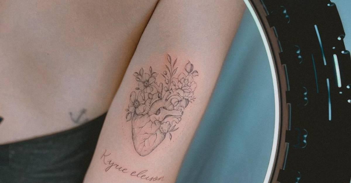 Fine line anatomical heart and flowers tattoo on the