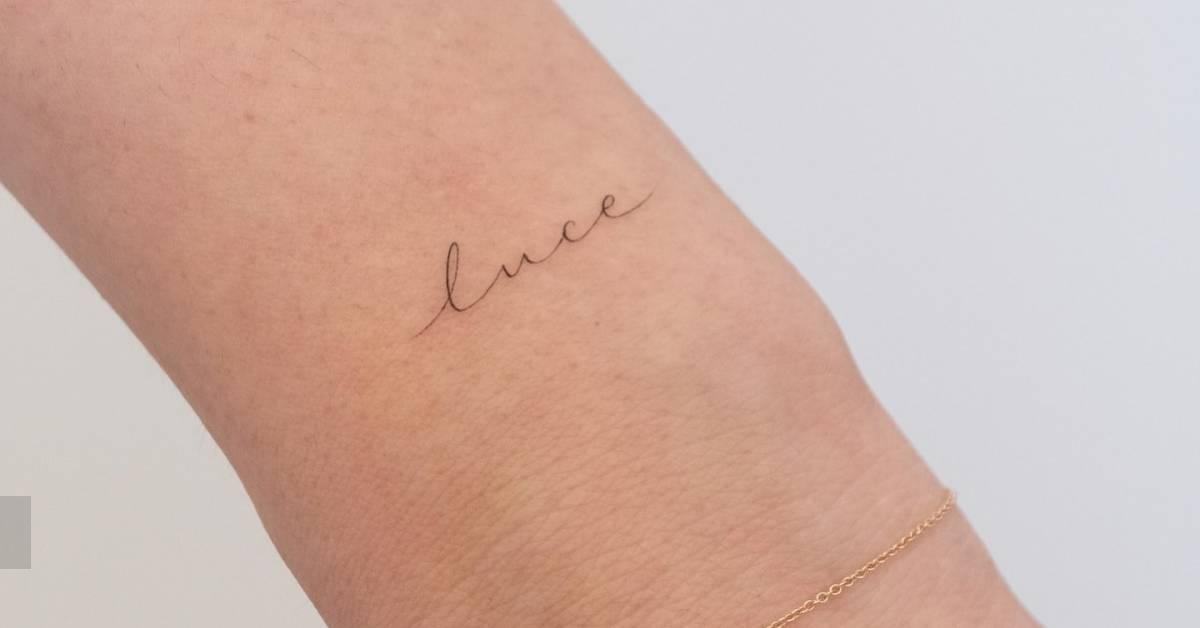 Handwritten lettering tattoo of the word "luce" placed