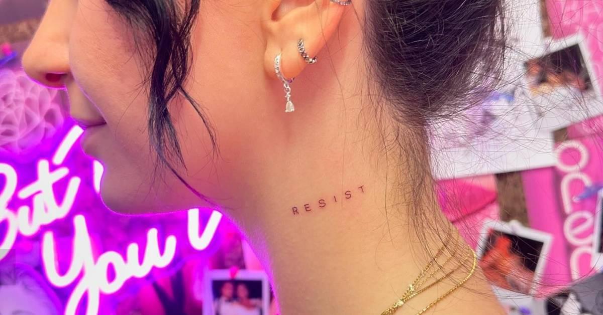 Lettering tattoo of the word "resist" placed on the
