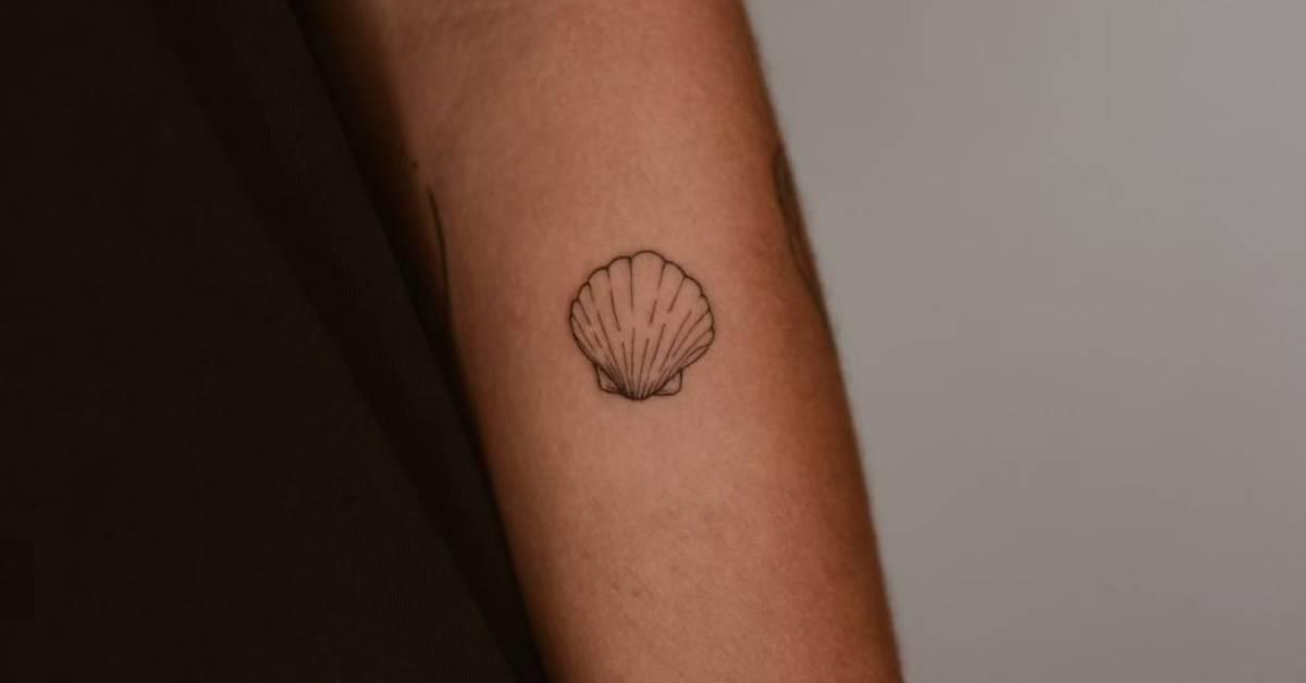 Fine line style scallop shell tattoo located on the