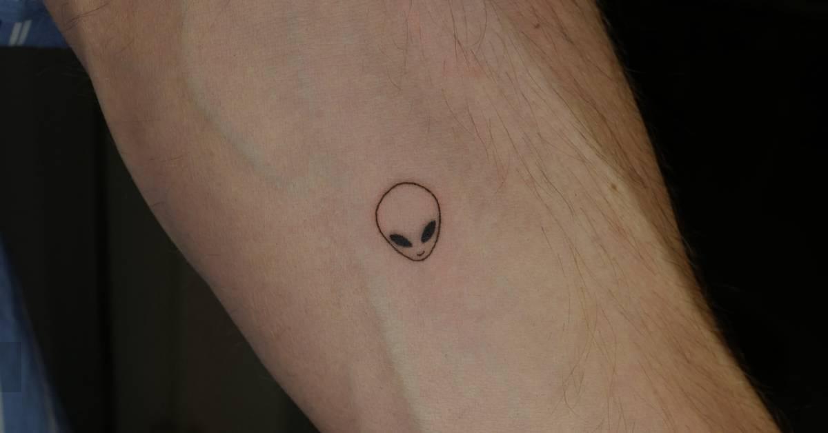 Minimalistic style alien head tattoo located on the