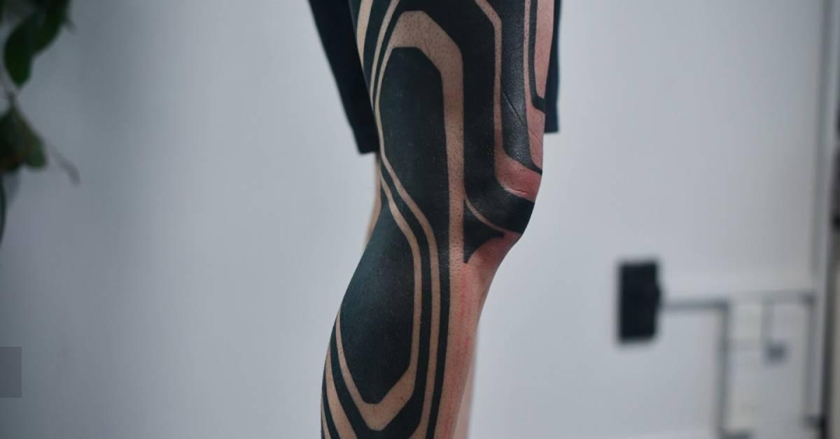 Cybernetic leg sleeve tattoo in blackwork style.